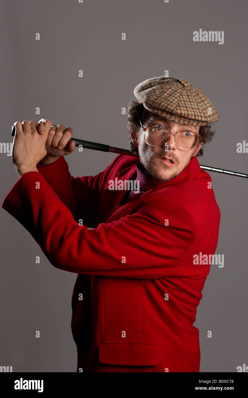 Studio portrait of golfer in red blazer and cap with golf club Stock ...