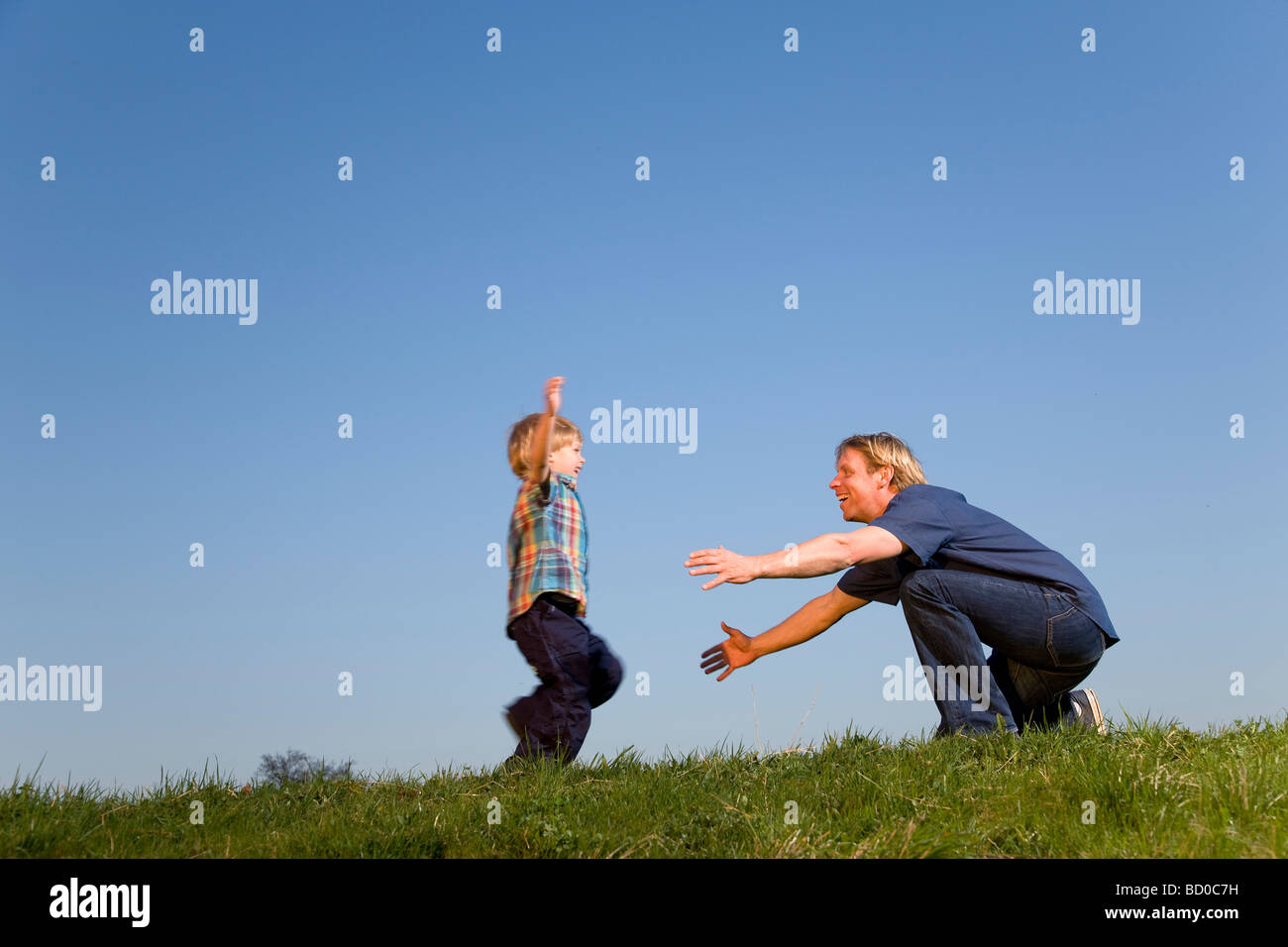 boy running into father's arms Stock Photo - Alamy