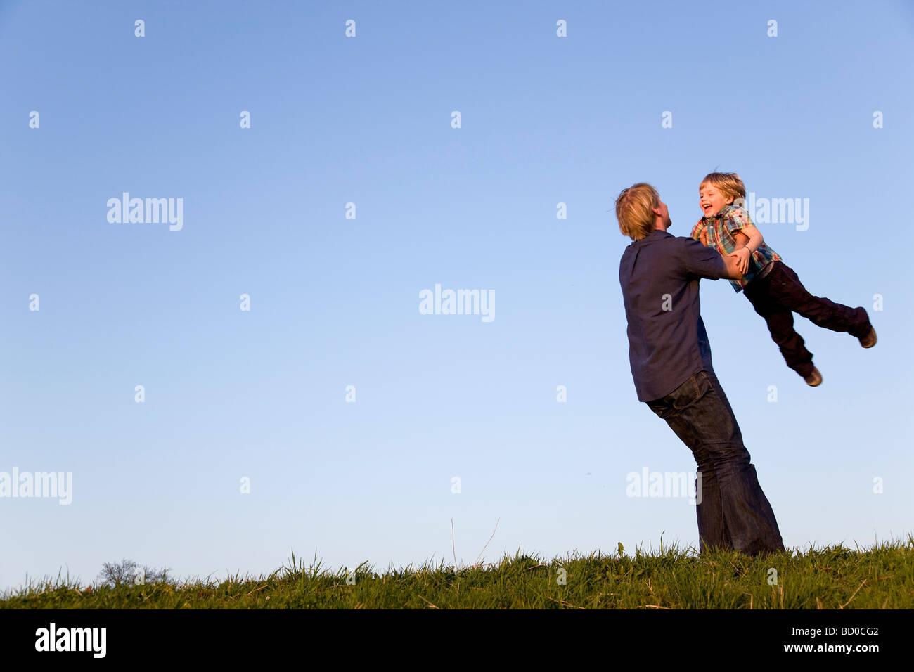 father spinning boy in his arms Stock Photo - Alamy