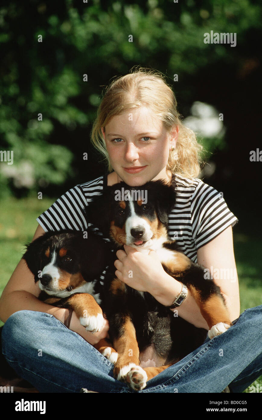 girl with two Bernese mountain dog puppys Stock Photo - Alamy