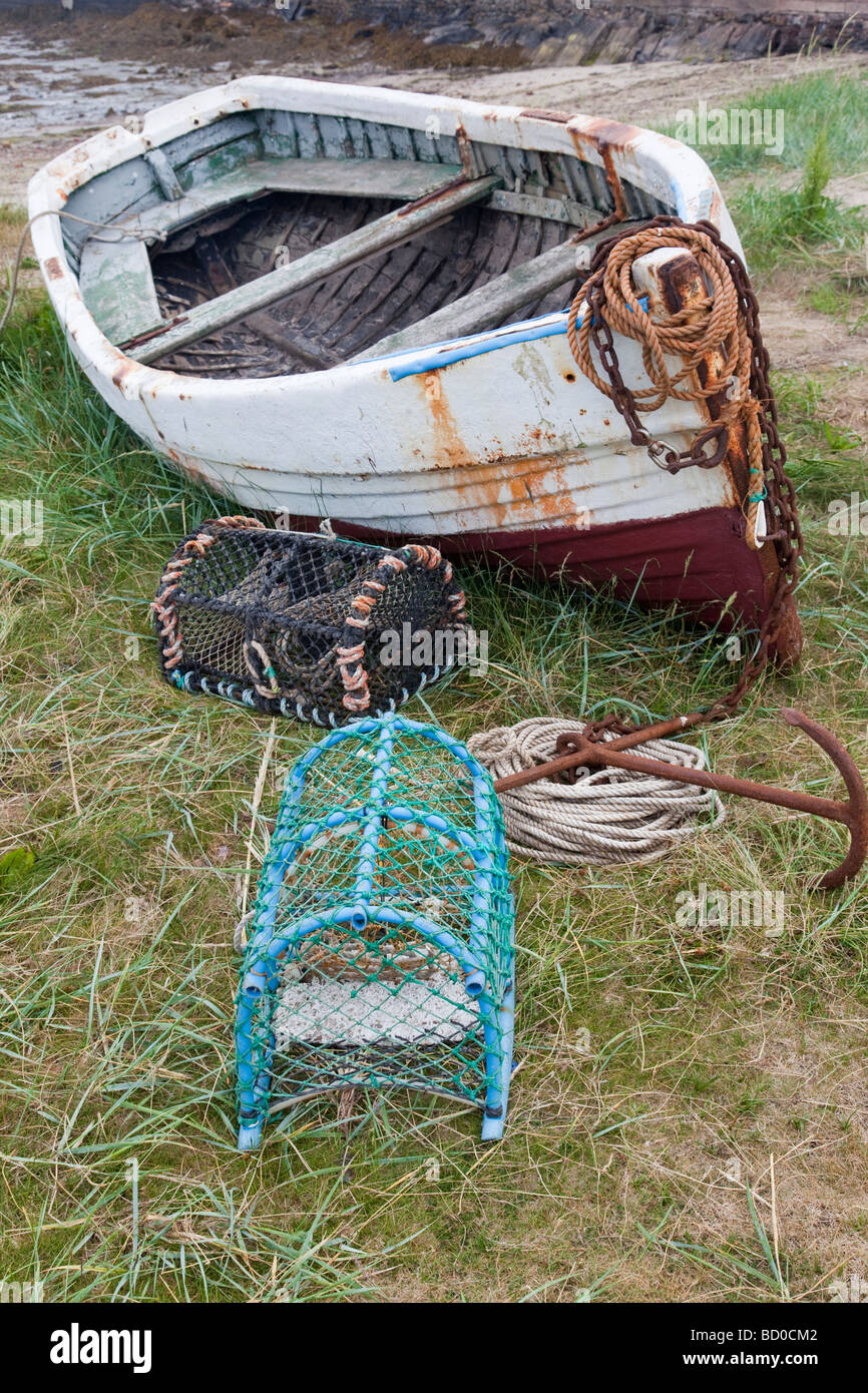 Beached boat with anchor and pots Stock Photo - Alamy