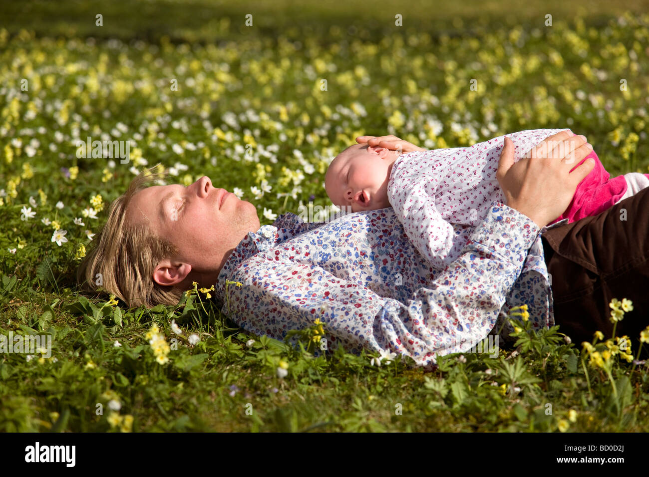 man with baby sleeping in grass Stock Photo - Alamy