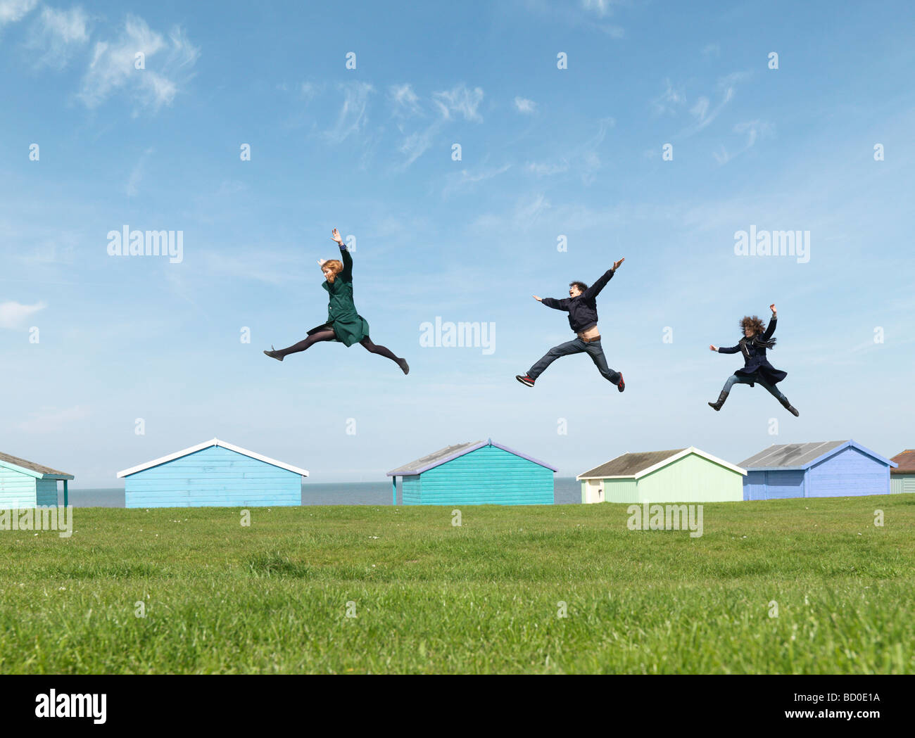 Friends jumping across roofs by seaside Stock Photo - Alamy