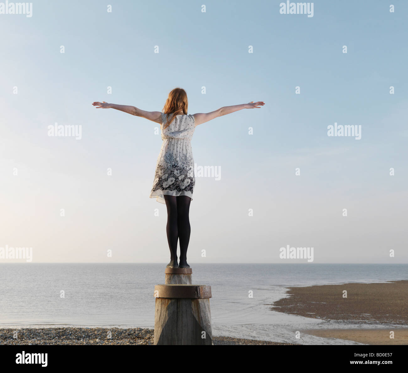 Woman balancing on wooden post Stock Photo - Alamy