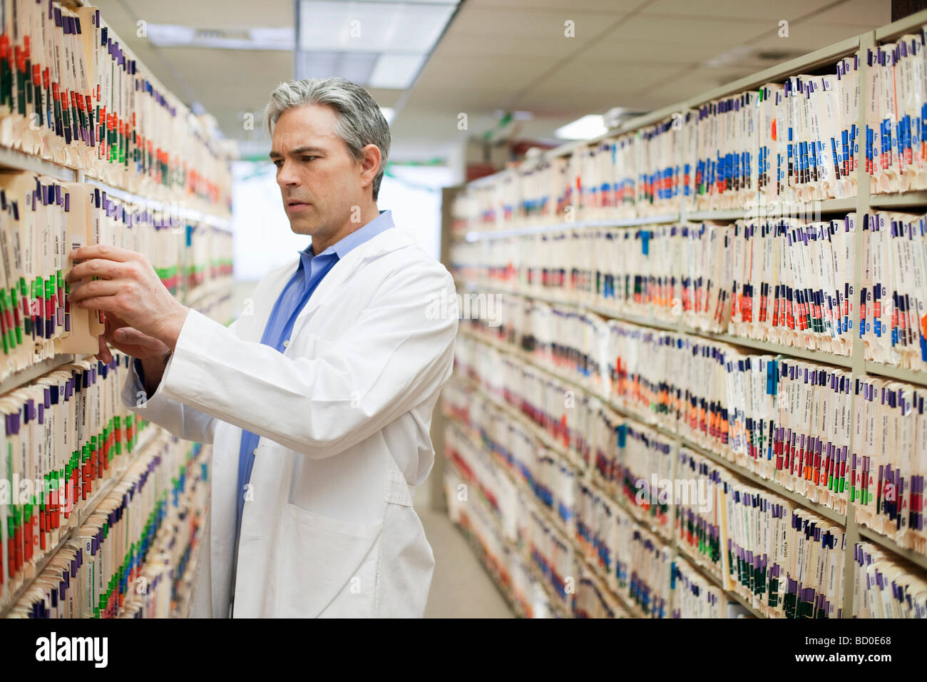 Male Doctor searching medical files Stock Photo - Alamy