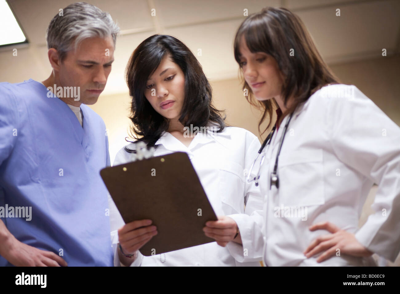 Female Doctors and surgeon reading file Stock Photo - Alamy