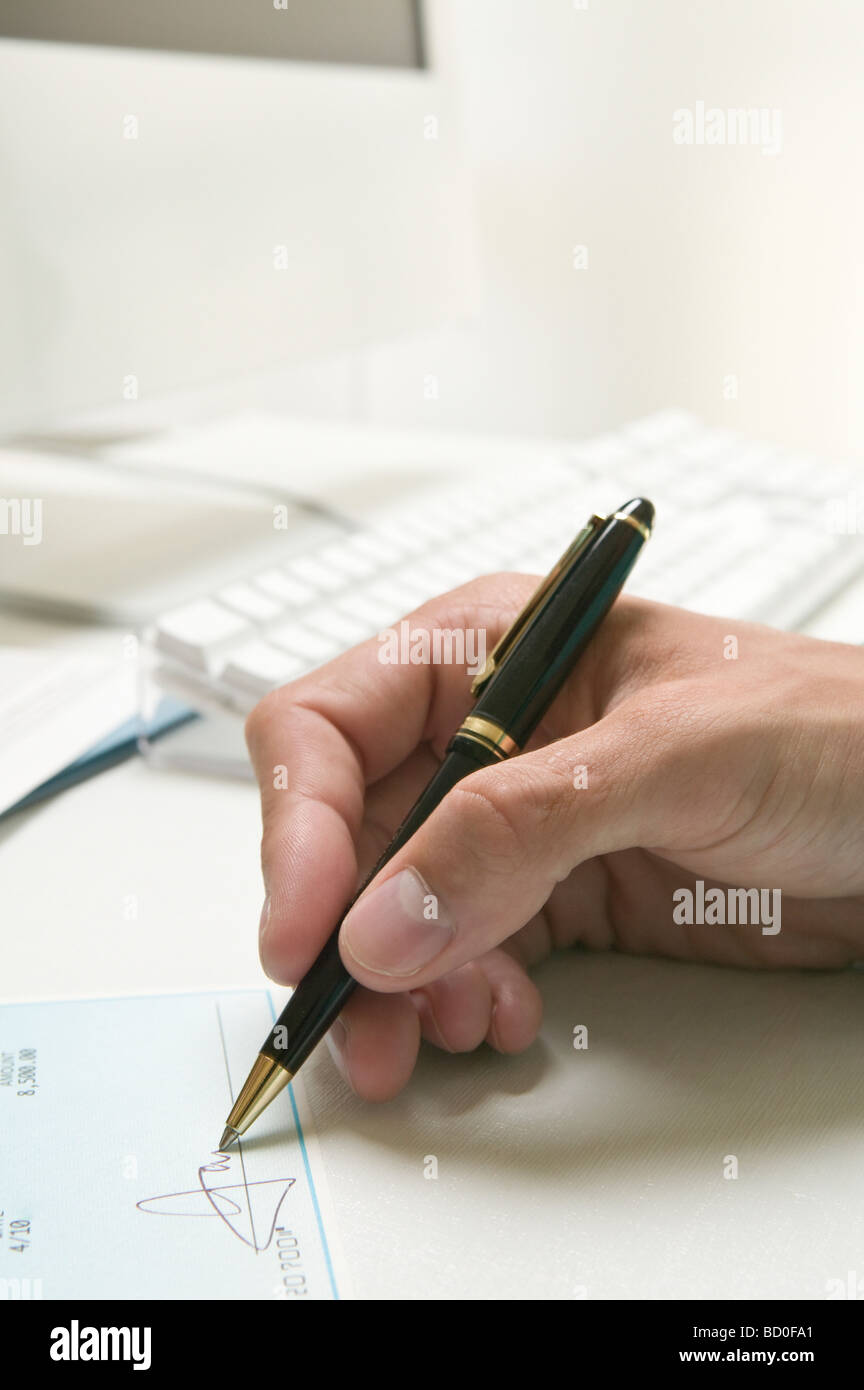 Hand signing check hi-res stock photography and images - Alamy
