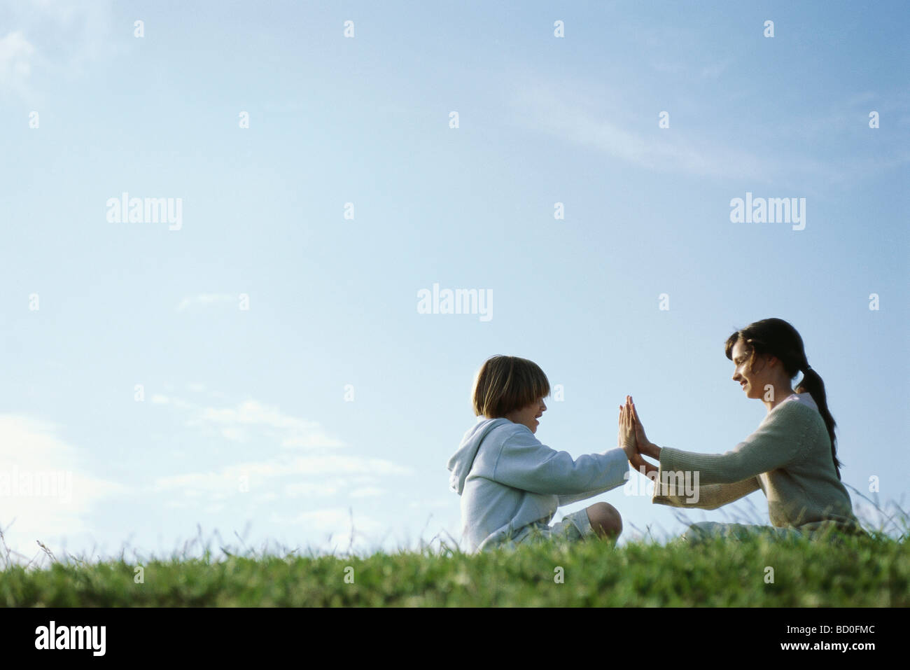 Brother and sister playing clapping game outdoors Stock Photo - Alamy