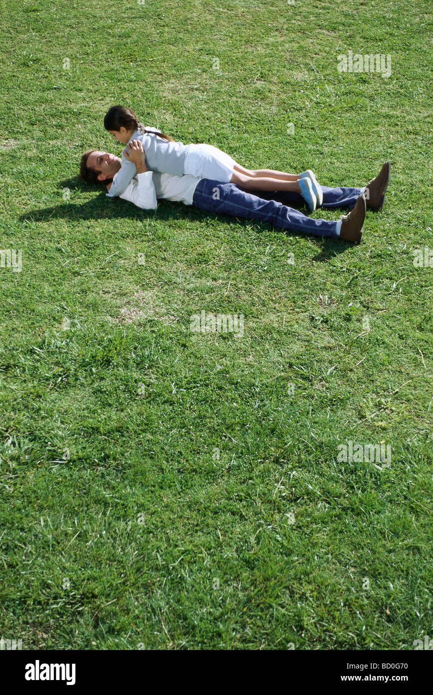 Father and daughter lying together in grassy field Stock Photo - Alamy