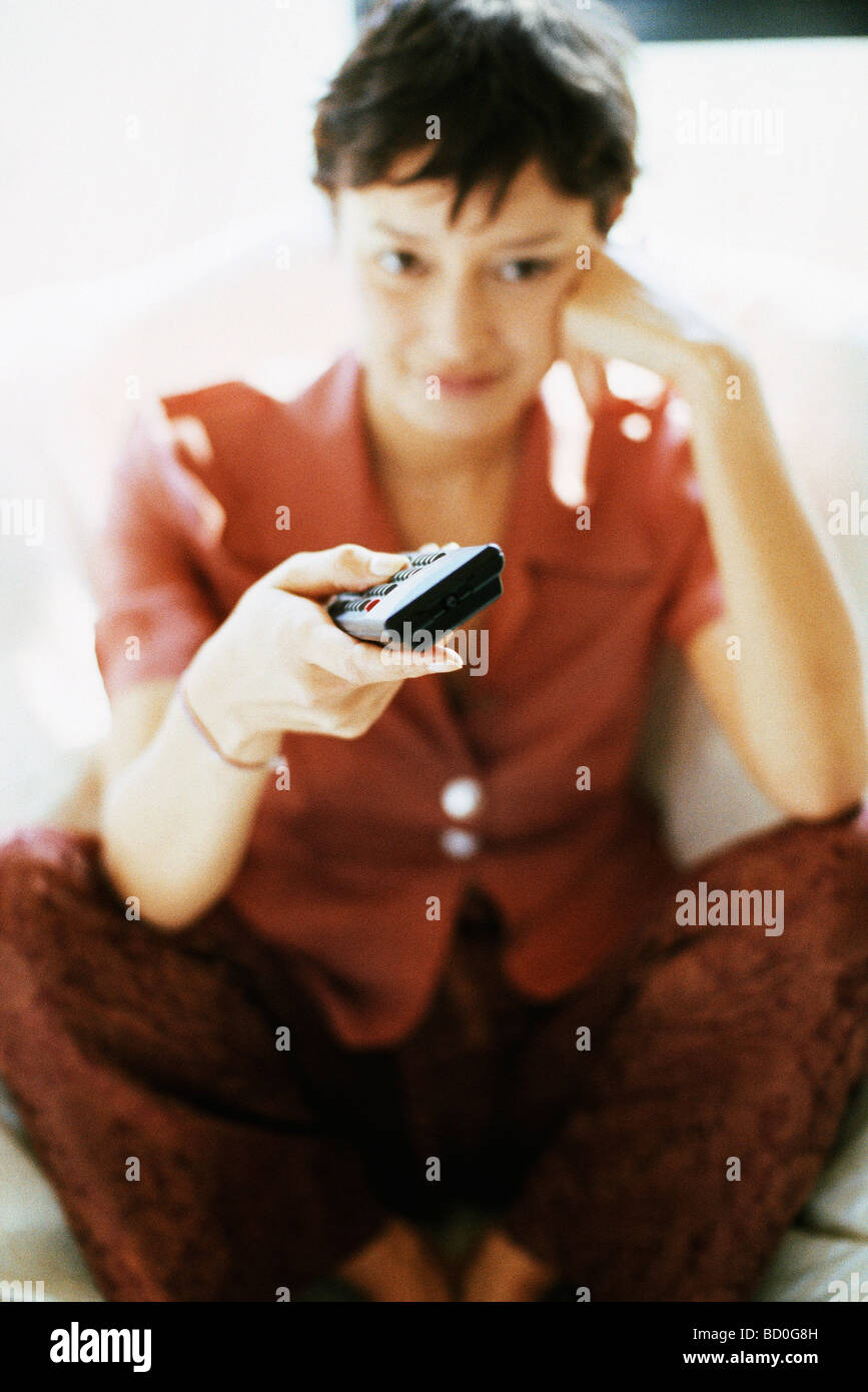 Woman watching television changing channels hi-res stock photography ...
