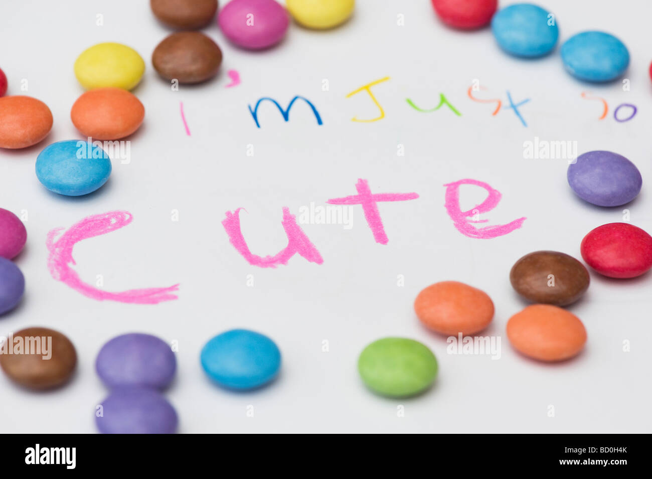 Childs spelling 'im so cute' and smarties on white Stock Photo - Alamy