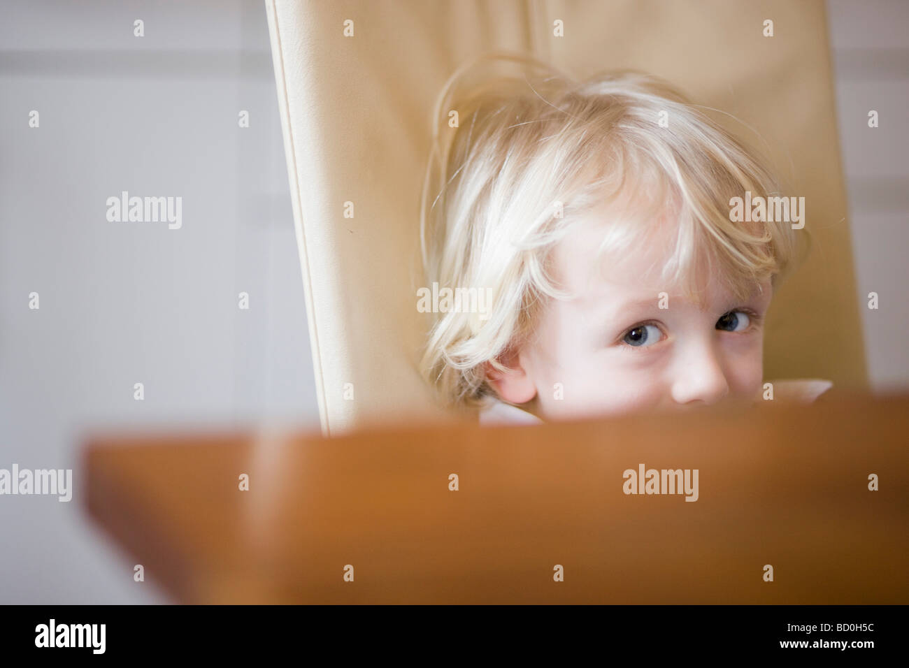 boy looking over table edge Stock Photo - Alamy