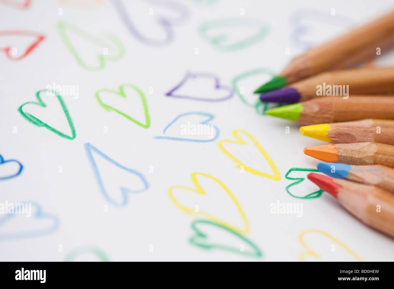 Childrens drawing of coloured love hearts with colouring pencils on a ...
