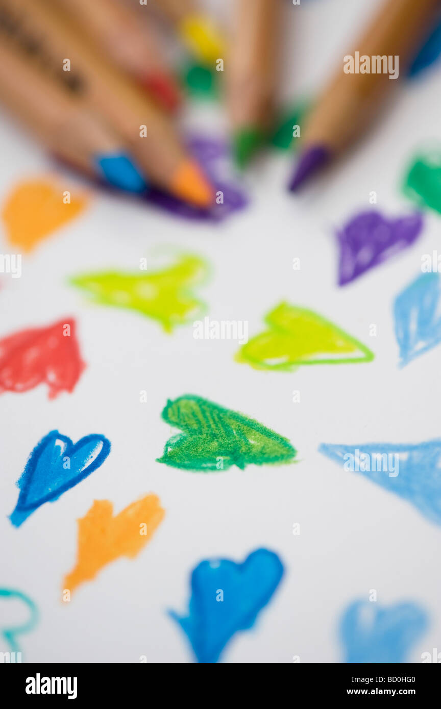 Childrens drawing of coloured love hearts with colouring pencils on a ...