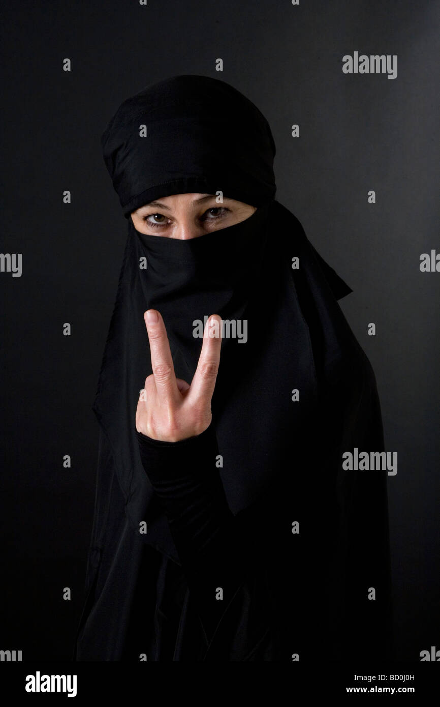 Islamic muslim woman wearing a burqa niqab burka and making a v sign ...