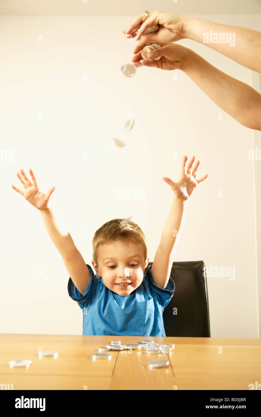 boy and falling coins Stock Photo - Alamy