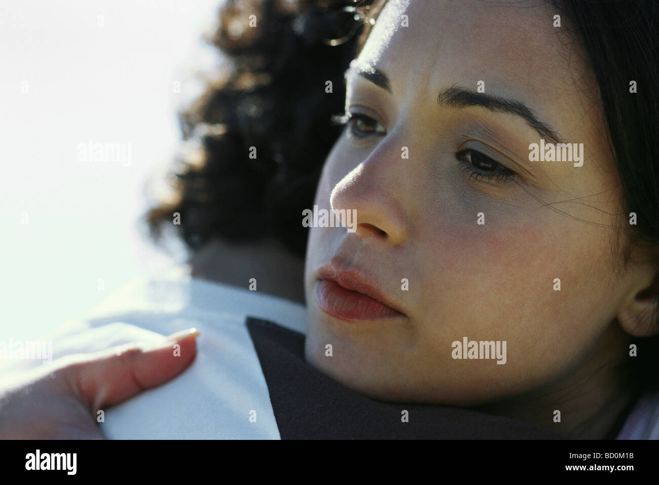 Young woman embracing man with look of disappointment Stock Photo - Alamy