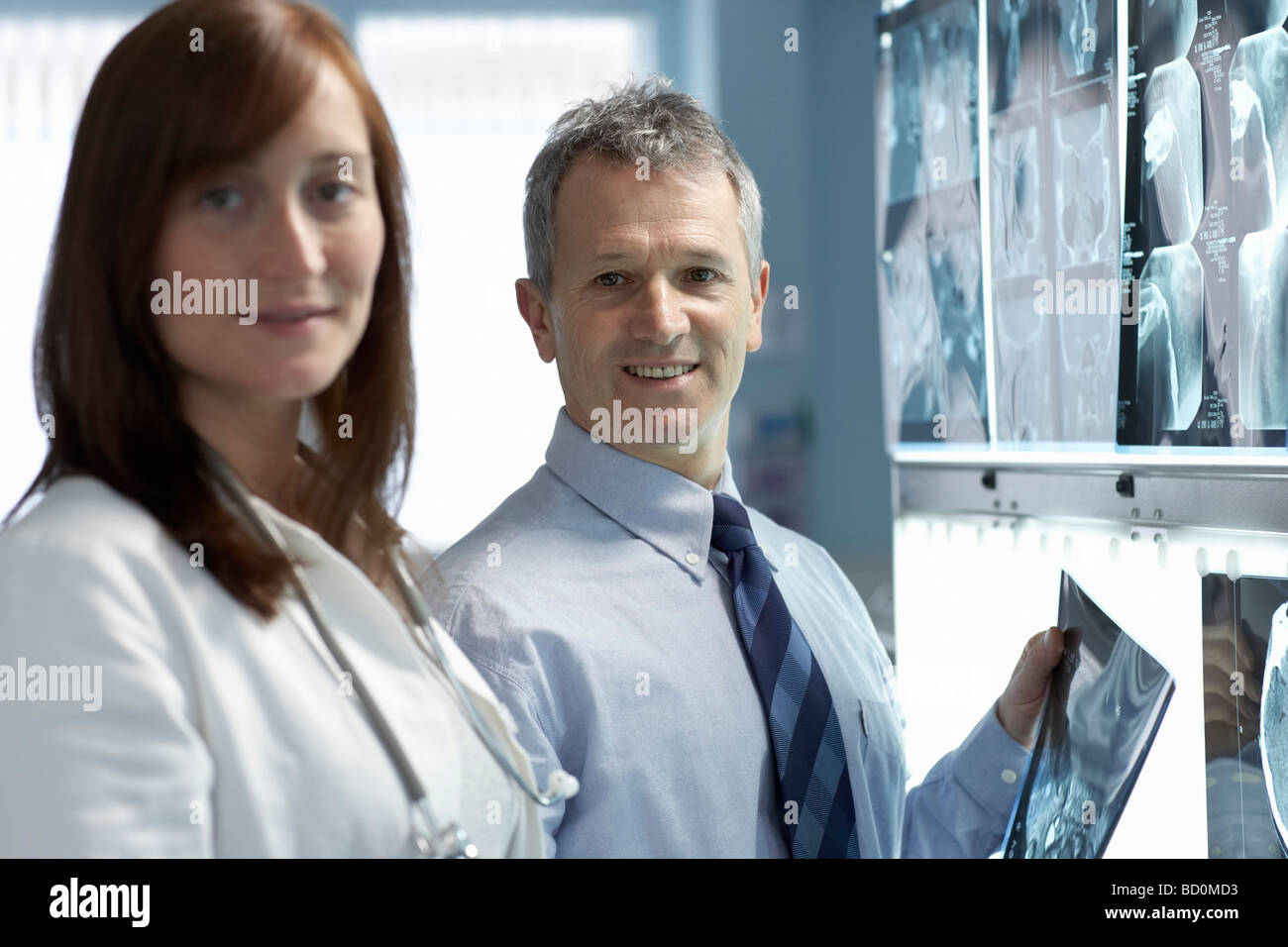 Two doctors, smiling, x-rays behind Stock Photo - Alamy