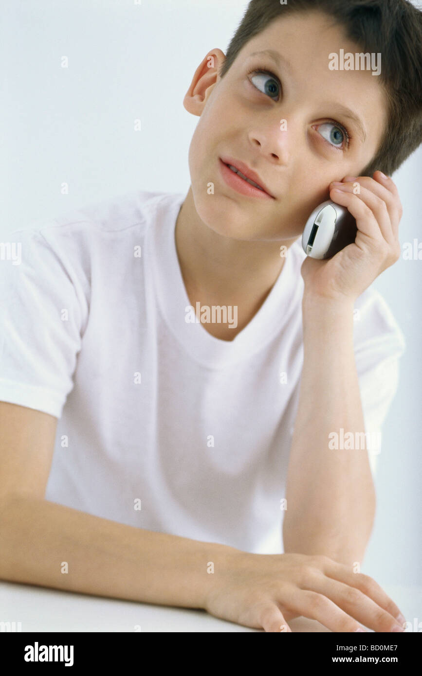 Boy using cell phone, glancing sideways Stock Photo - Alamy