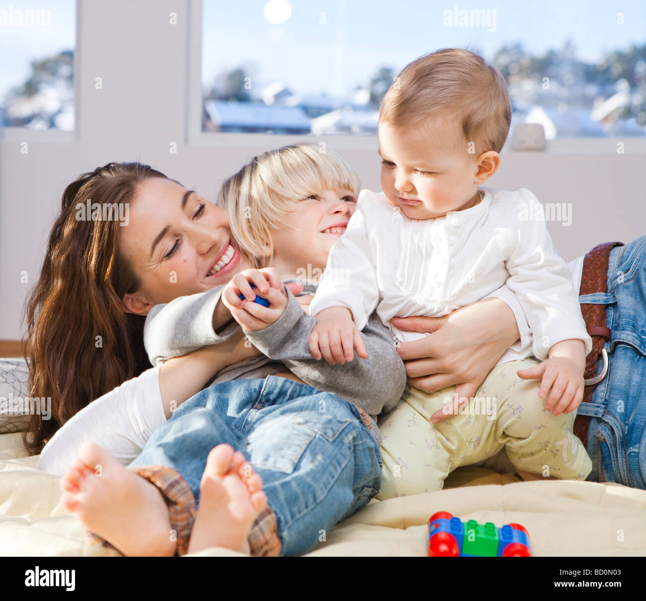 Mother and children cuddling and playing Stock Photo - Alamy