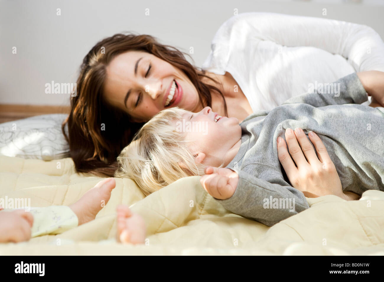 Mother and children cuddling and playing Stock Photo - Alamy