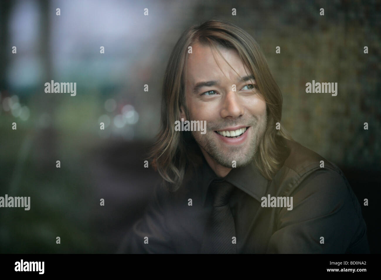 Businessman smiling through window Stock Photo - Alamy