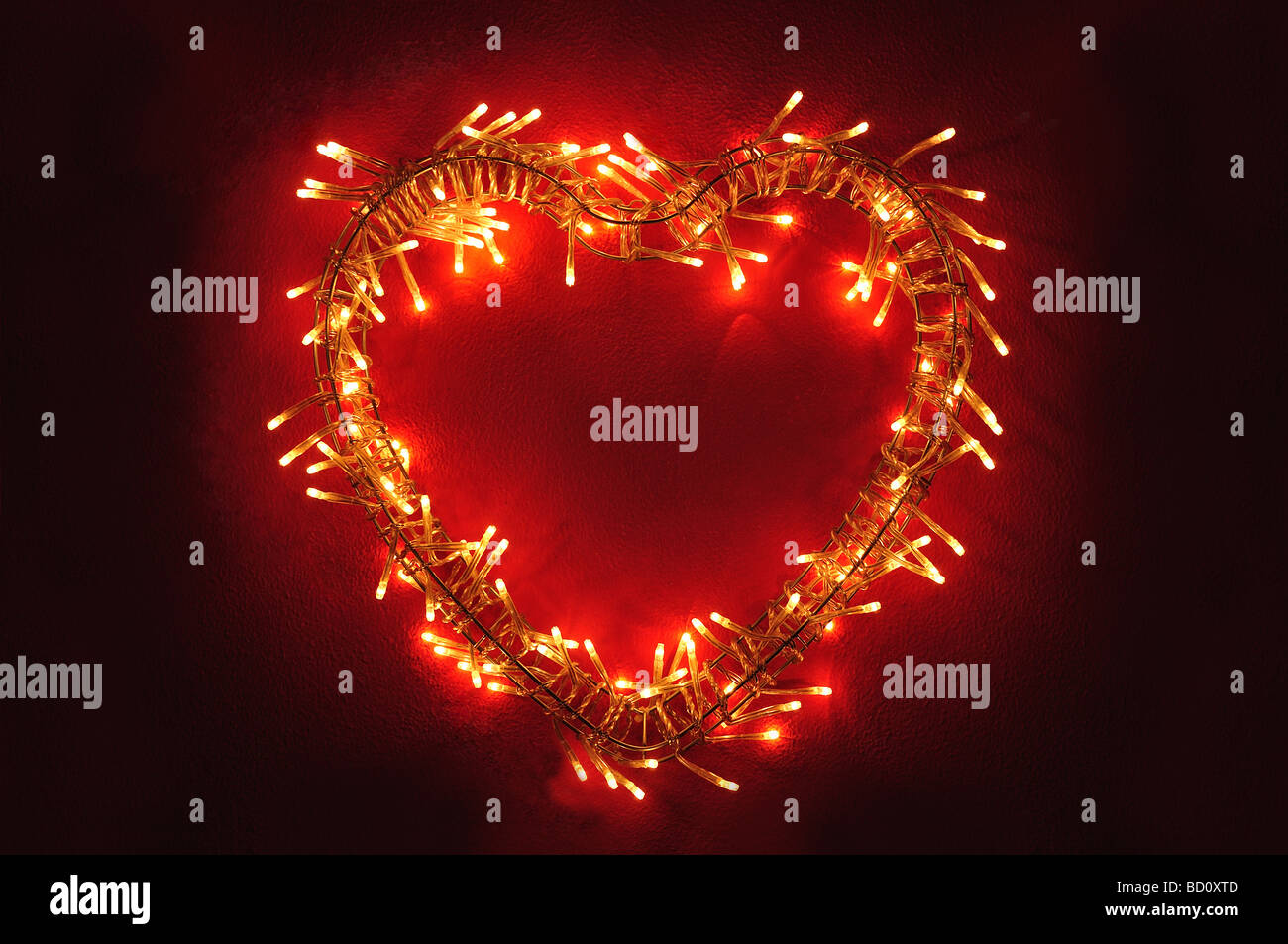 heart symbol made of lights on red background Stock Photo - Alamy