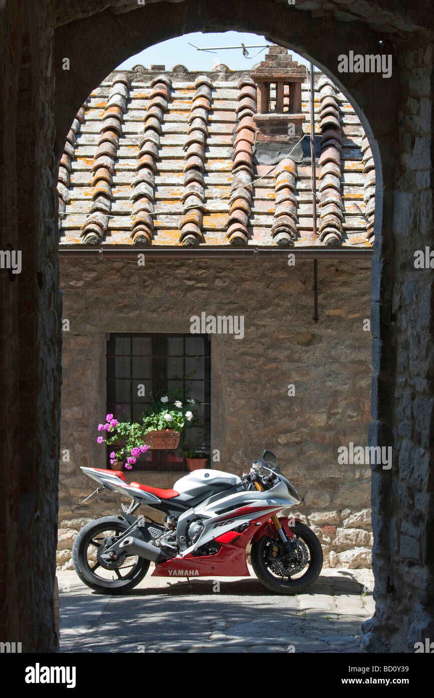 Motorcycle parked under window in front of tunnel in Tuscany Italy ...
