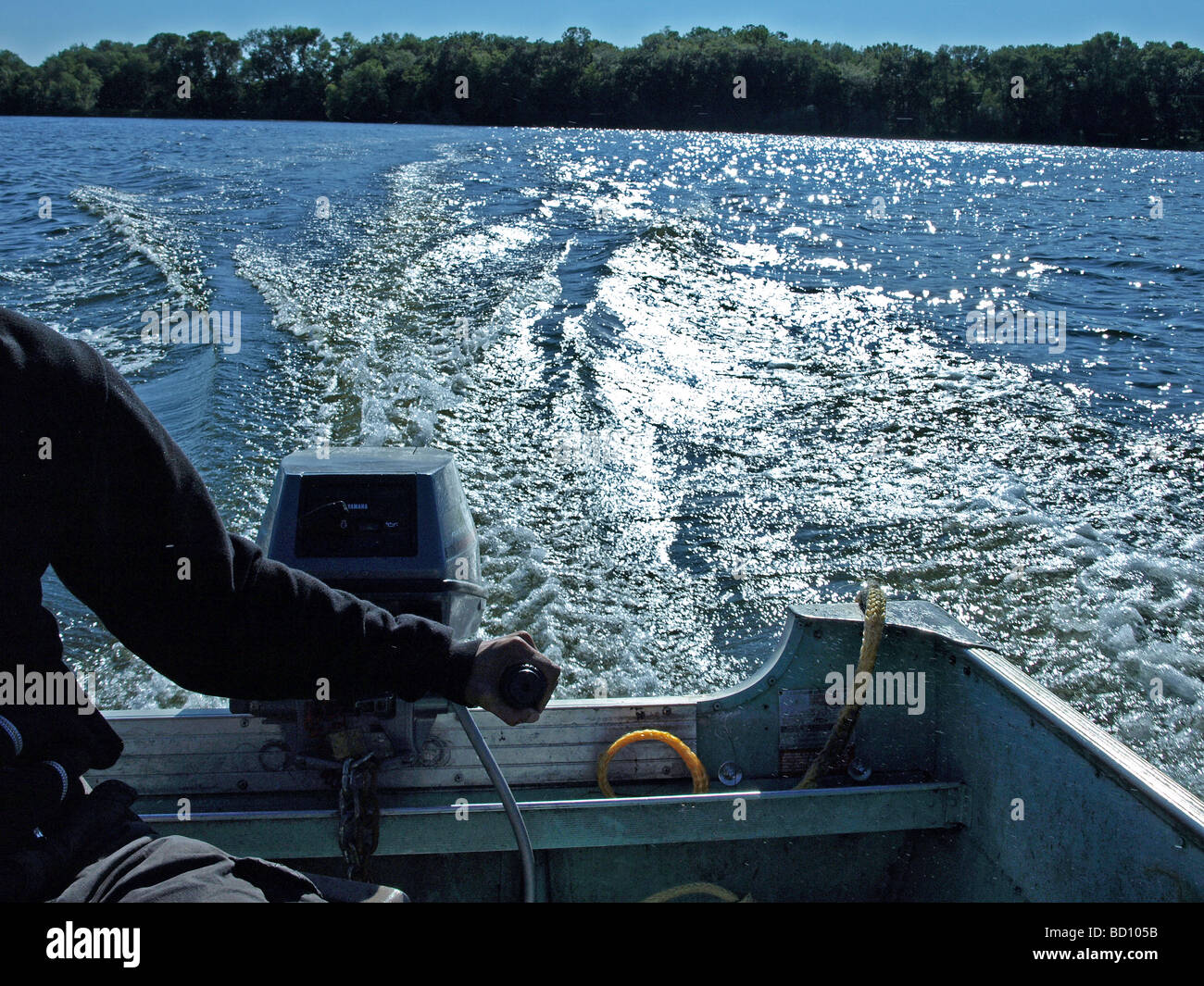 motorboat boat with motor on a lake with tree line in background and a ...