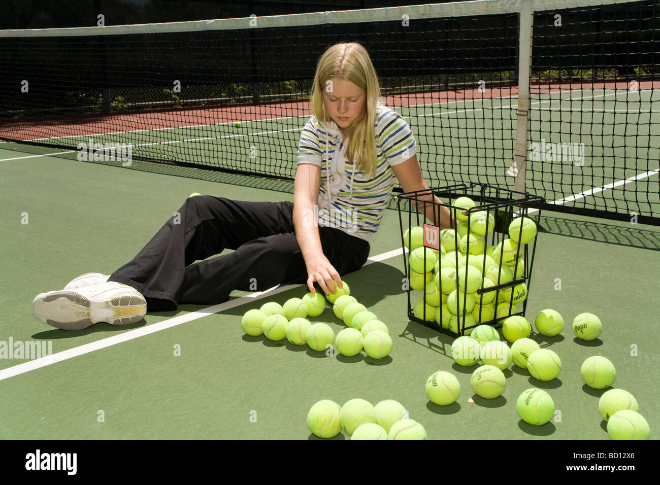 6th grade girl building an isosceles triangle of tennis balls. MR Stock ...