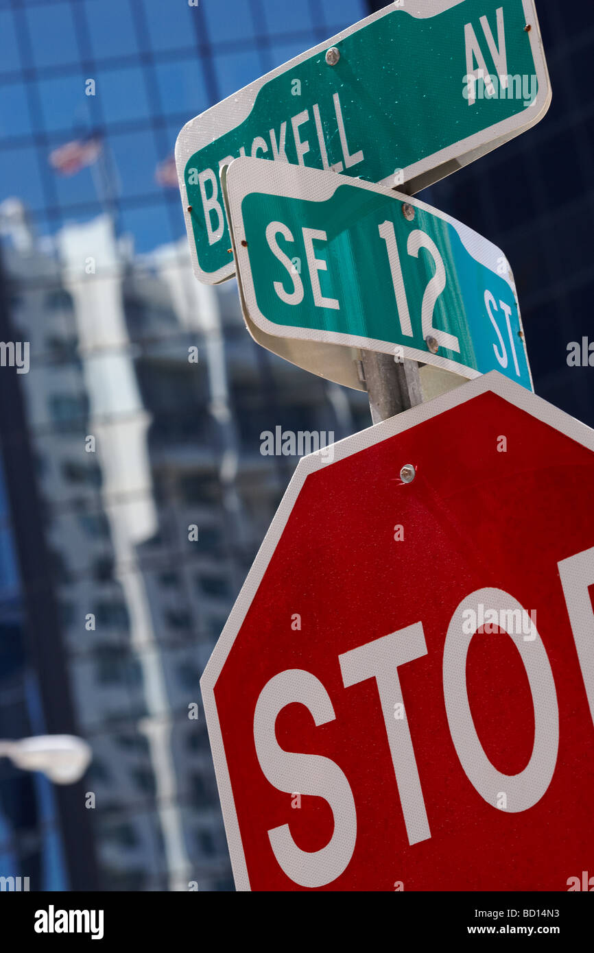 STOP and street signs in front of glass building in Miami, USA Stock ...