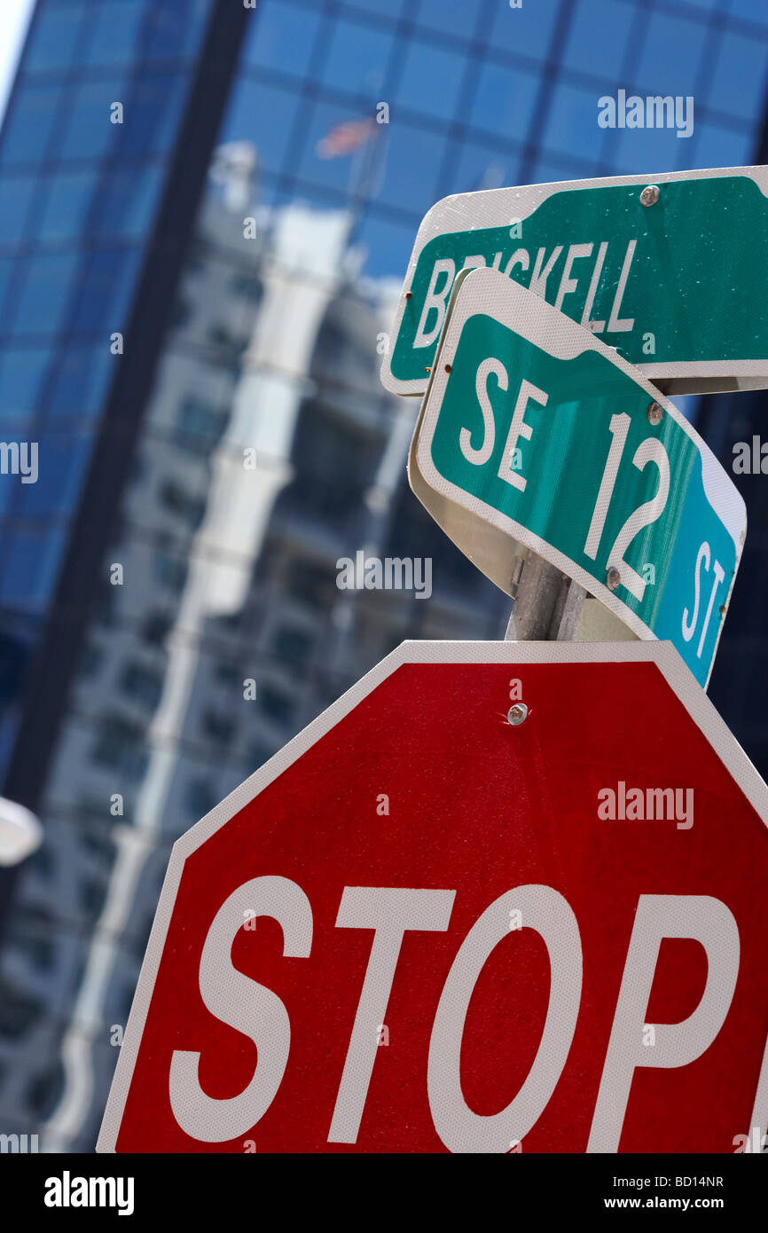 STOP and street signs in front of glass building in Miami, USA Stock ...