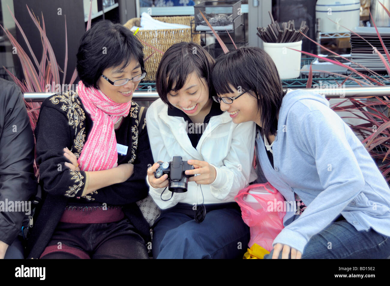 Happy Chinese women on vacation review a snapshot Stock Photo - Alamy