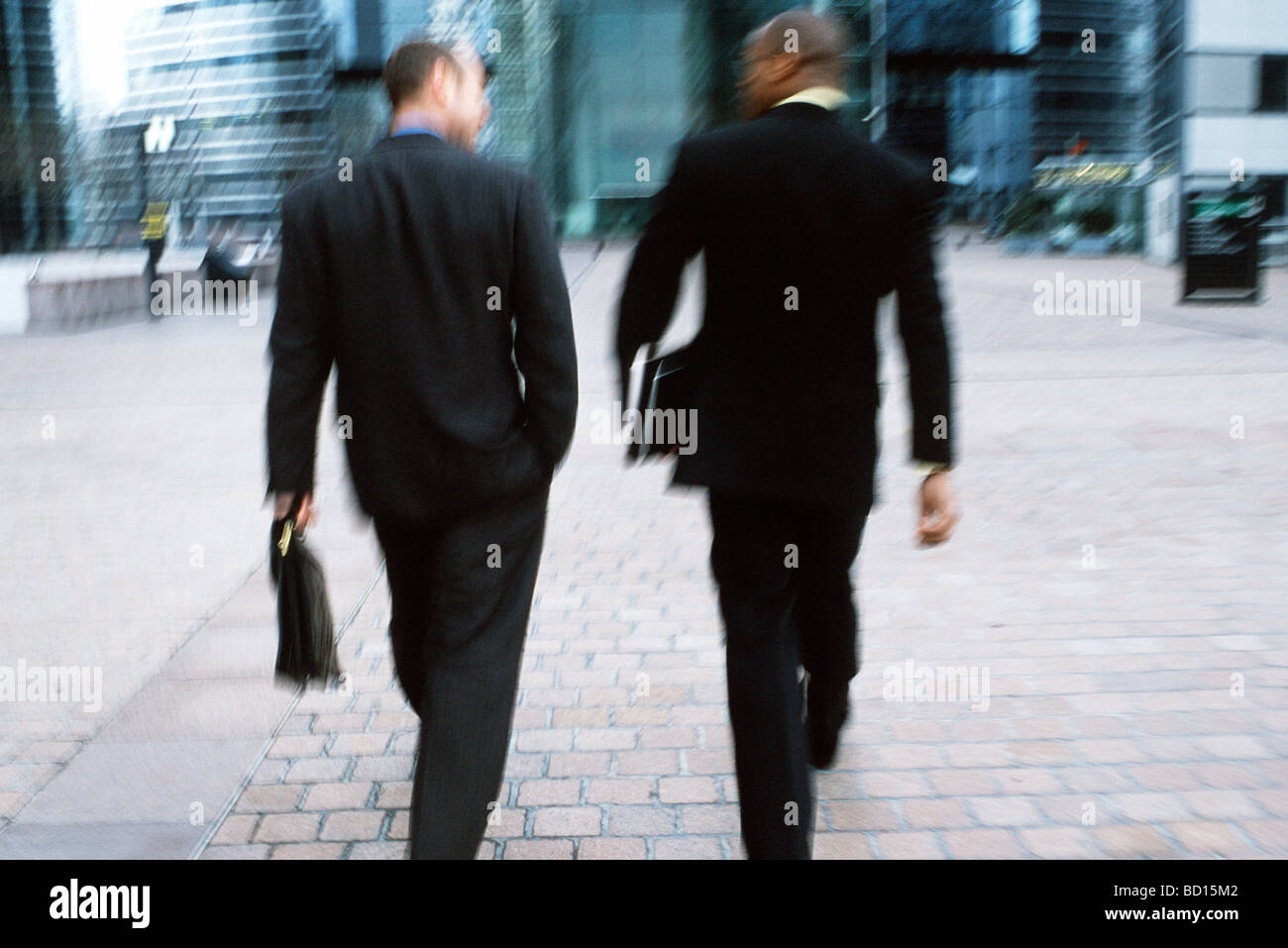 Businessmen walking together along city sidewalk Stock Photo - Alamy