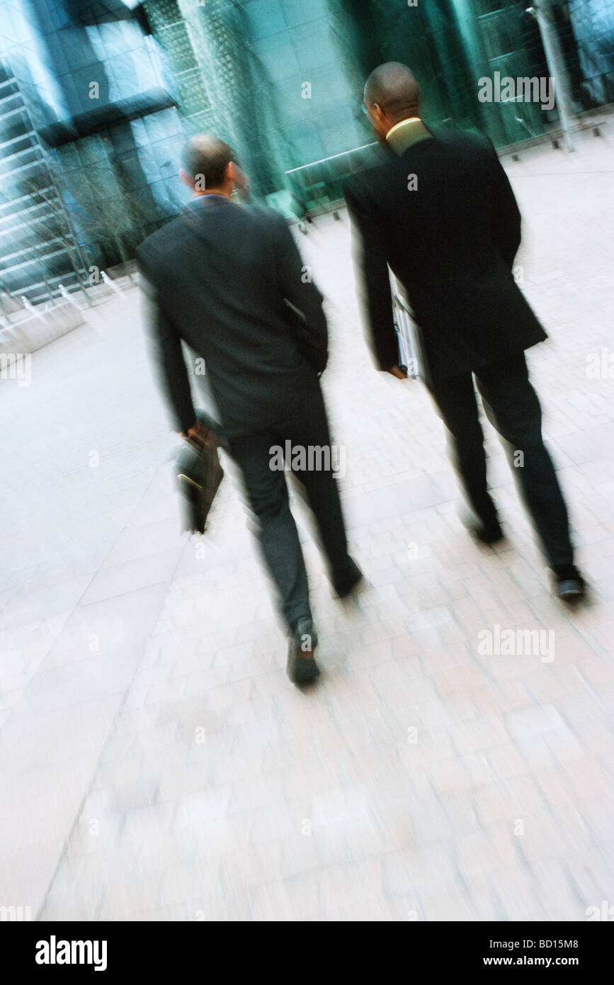 Businessmen walking together along city sidewalk Stock Photo - Alamy
