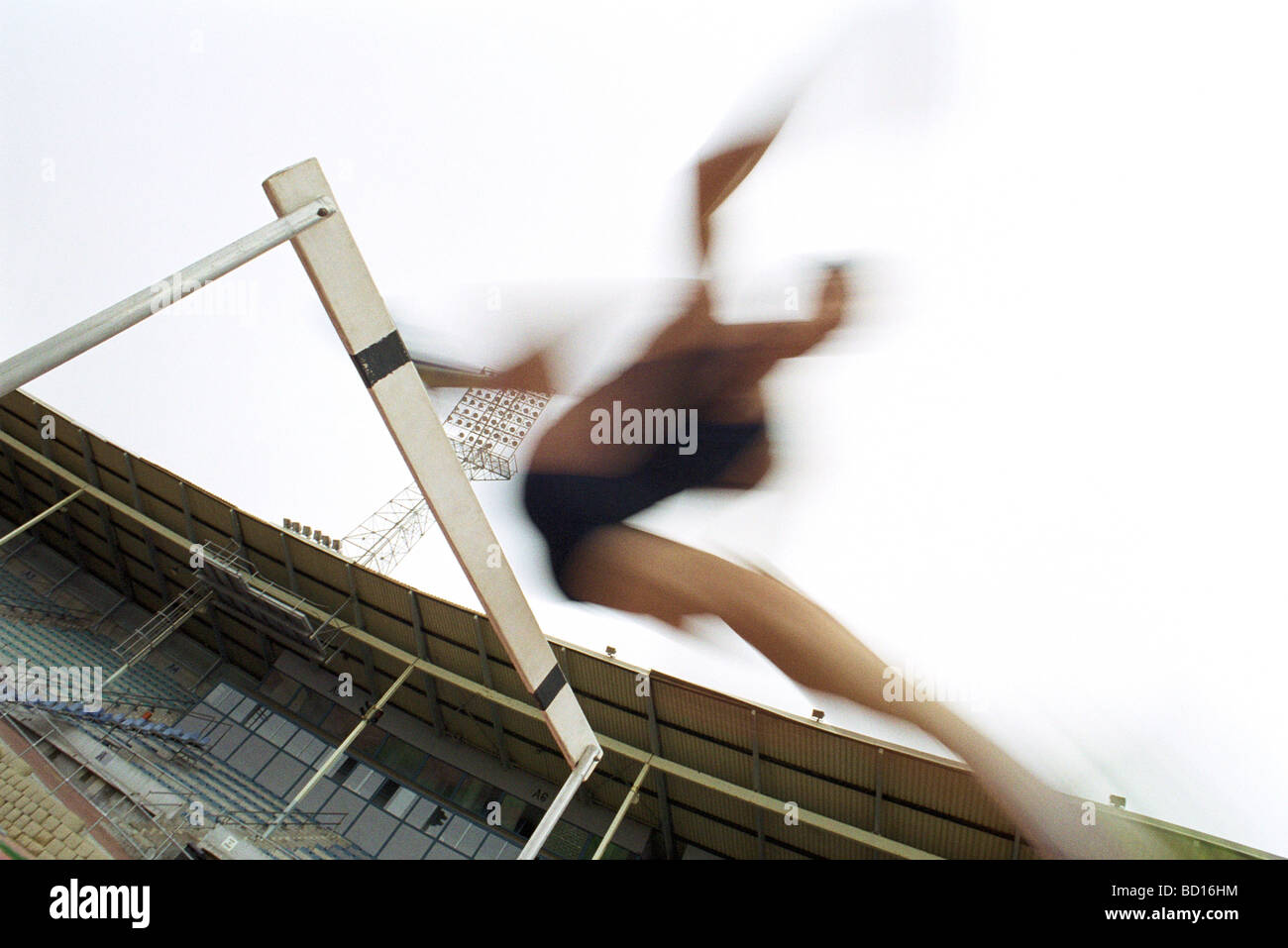 Runner jumping over hurdle, blurred Stock Photo - Alamy