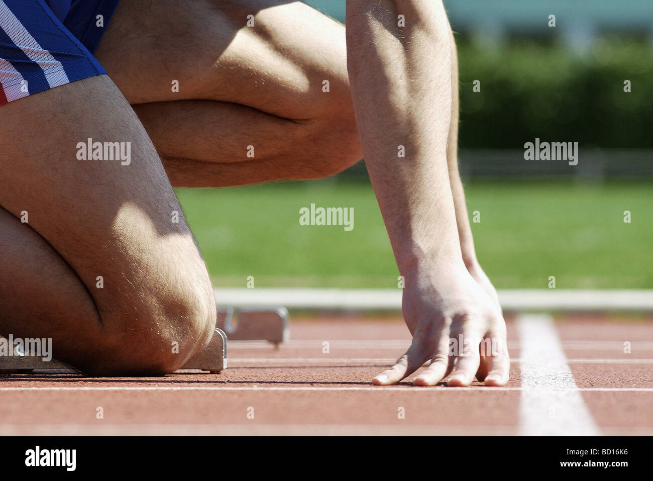 Runner crouching at starting line, cropped Stock Photo - Alamy