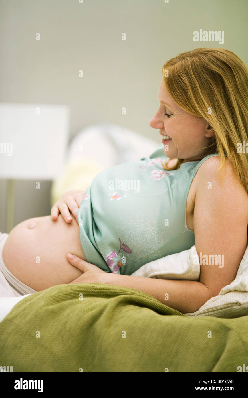 Pregnant woman relaxing, hand on belly Stock Photo - Alamy