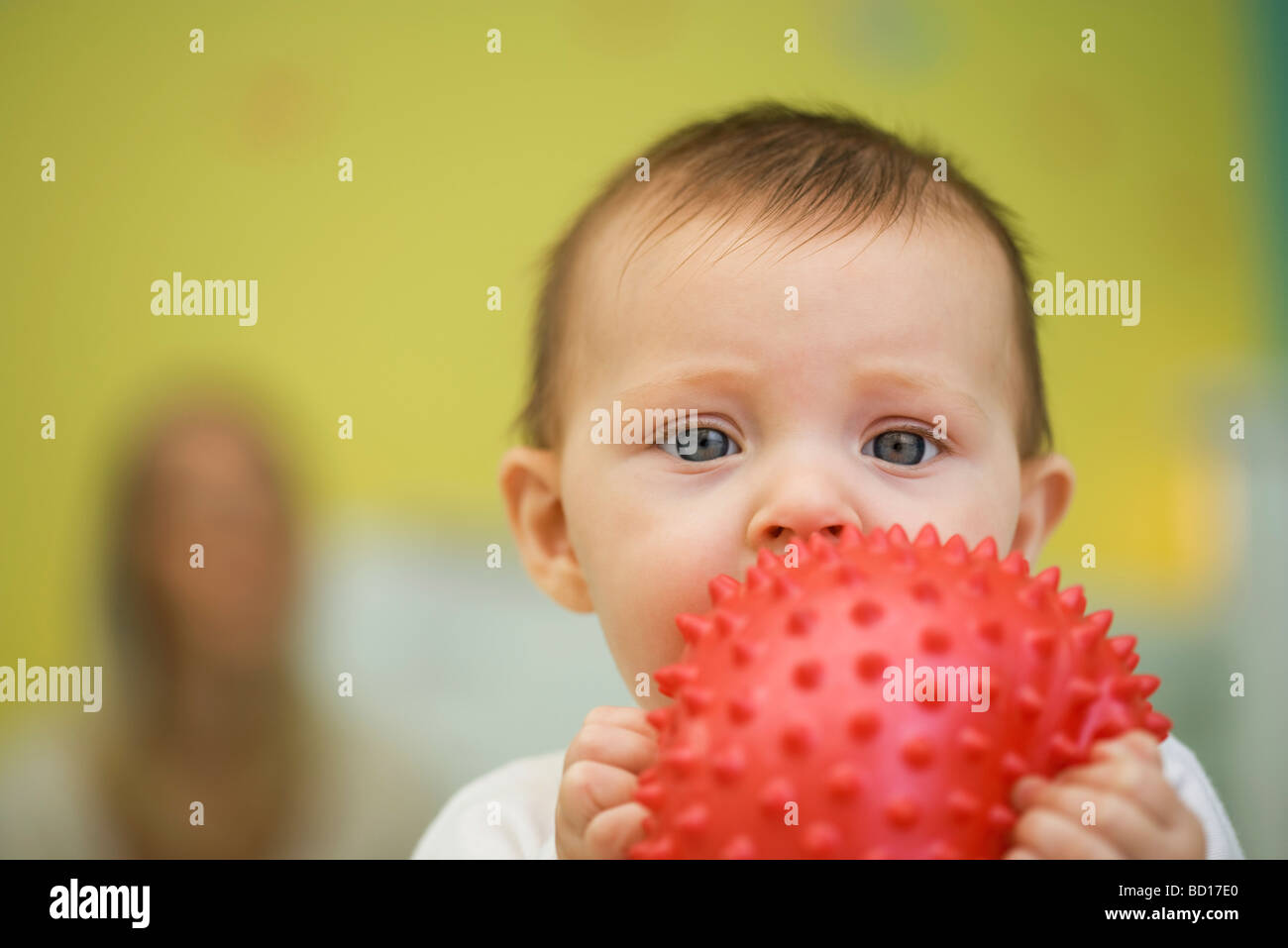 Baby holding toy in front of mouth Stock Photo - Alamy