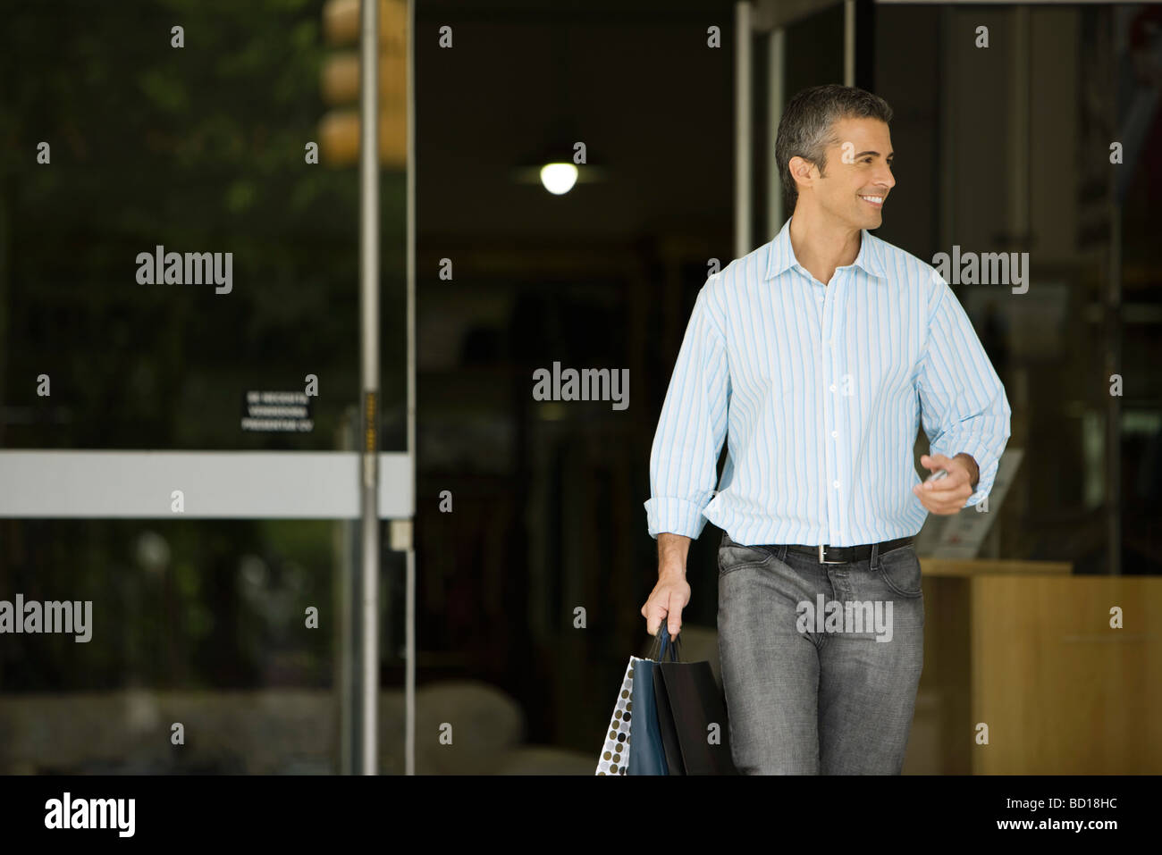 Man leaving store with shopping bags Stock Photo - Alamy