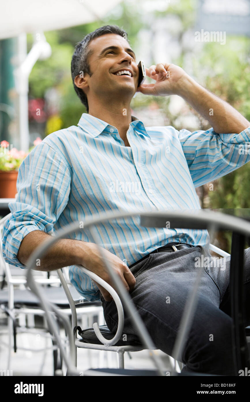 Man sitting outdoors using cell phone Stock Photo - Alamy
