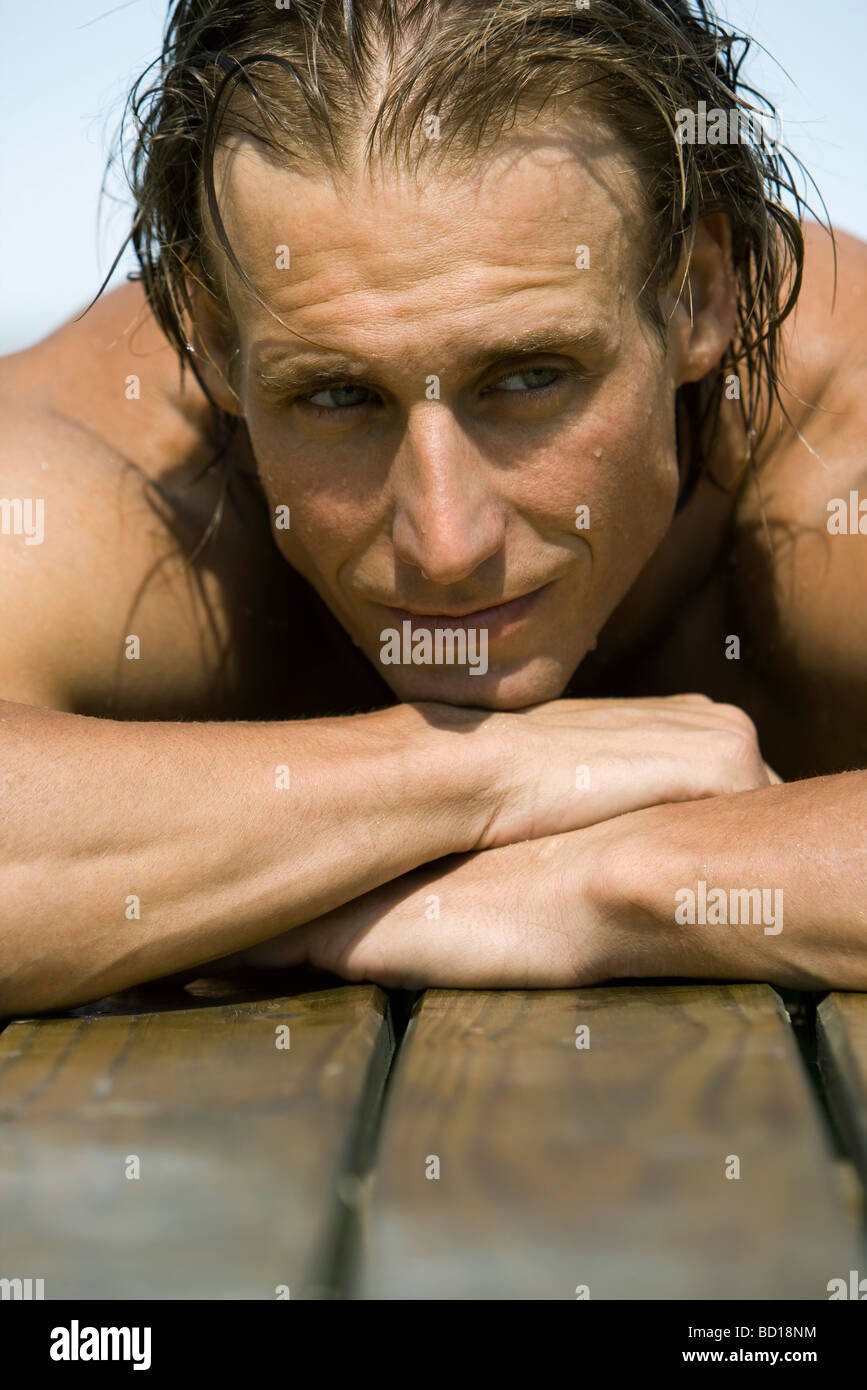Man resting head on arms on side of pool Stock Photo - Alamy