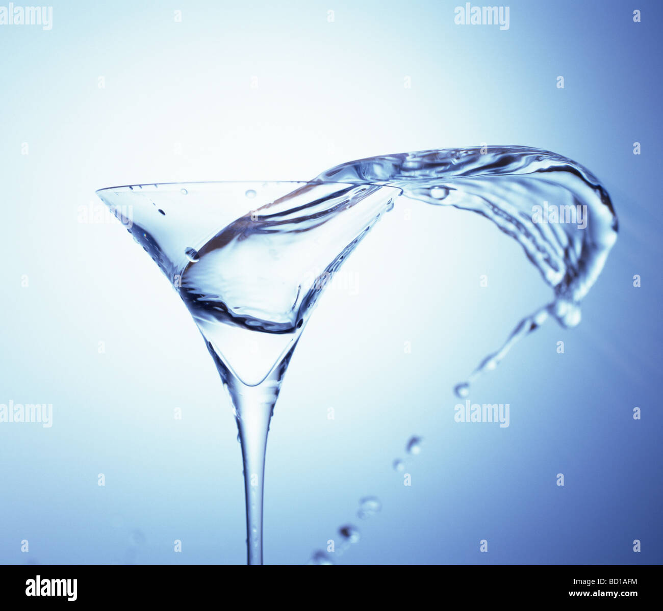 Water spread out from cocktail glass blue background Stock Photo - Alamy