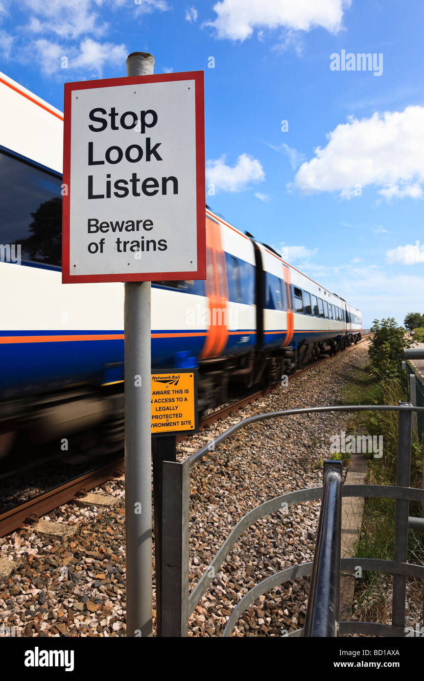 A Train at speed passes the Warning sign at the Railway Crossing at ...