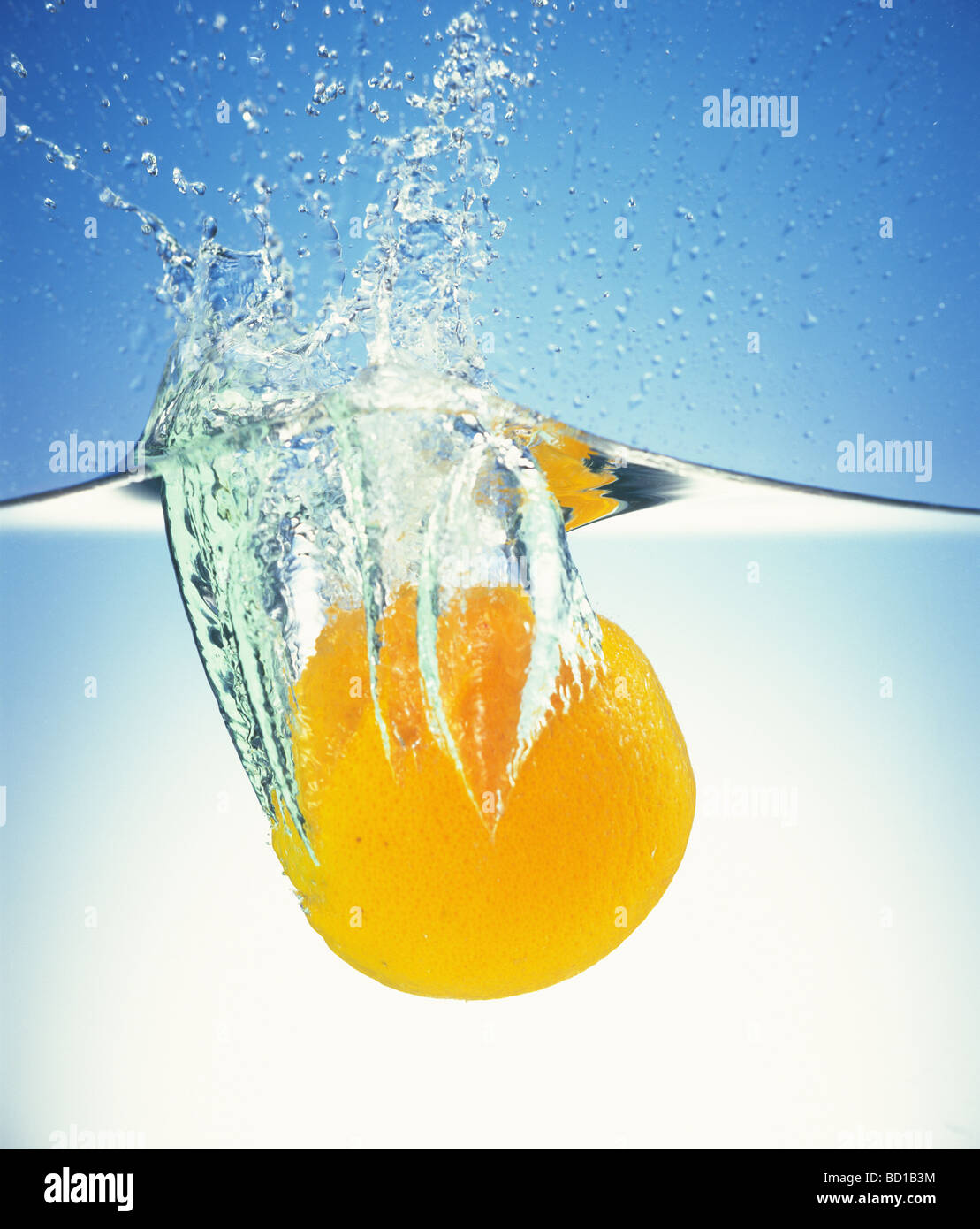 Orange falling into water Stock Photo - Alamy