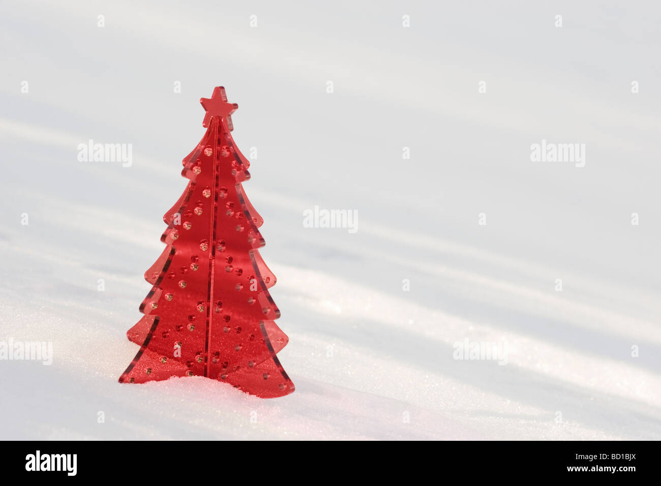 Red plastic Christmas tree decoration set in snow Stock Photo - Alamy