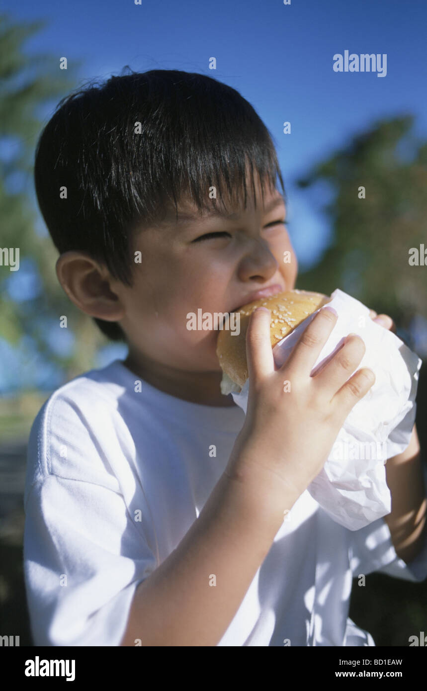 Boy eating hamburger Stock Photo - Alamy