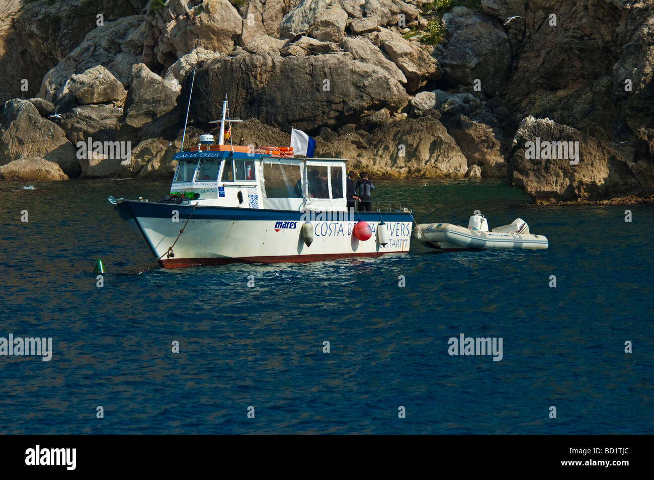 Dive boat with scuba divers anchoring in front of Medes Islands ...