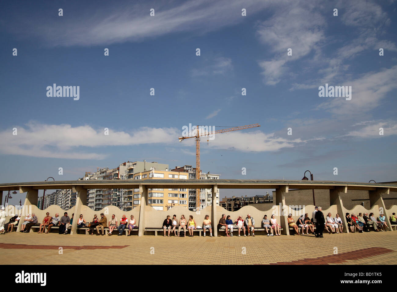 tourists sitting in the sun on the promenade in De Haan Belgium Stock ...