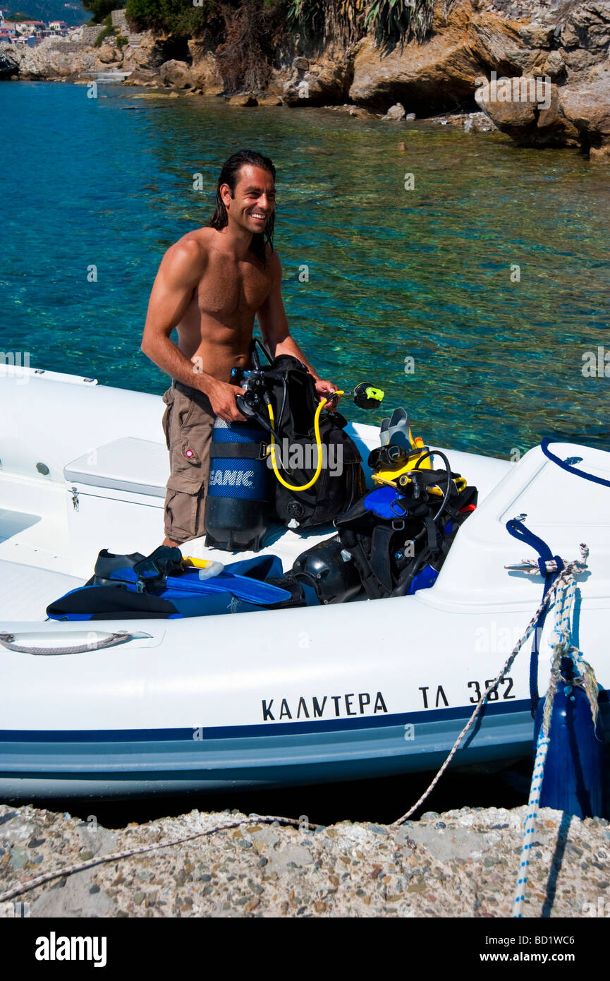 Scuba diver preparing diving gear on inflatable boat near Poros Greece ...